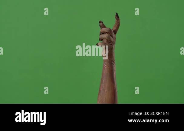 A creepy zombie hand points to the side, covered in dirt and decaying ...