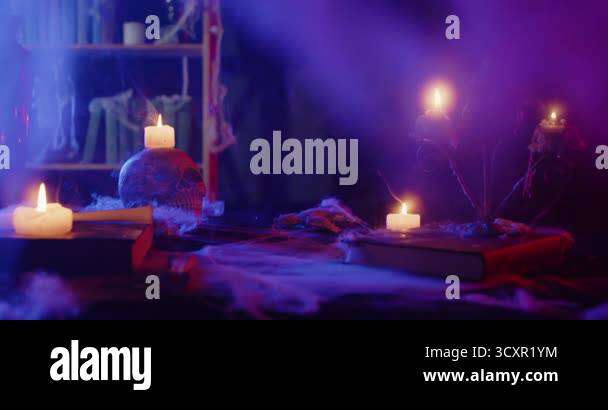 A spooky Halloween setup with lit candles on a table, surrounded by ...