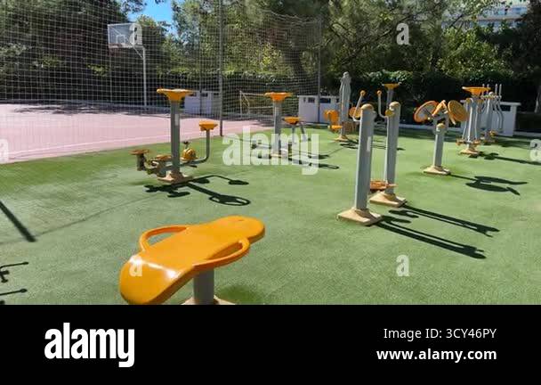 Outdoor fitness equipment is prominently displayed on lush green turf ...