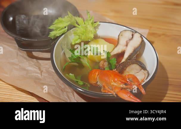 Hot fish soup with crayfish, potato, carrot and herbs served in a bowl ...