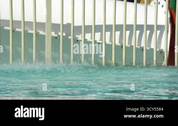 Close-up of water splashing at the bottom of a water slide behind ...
