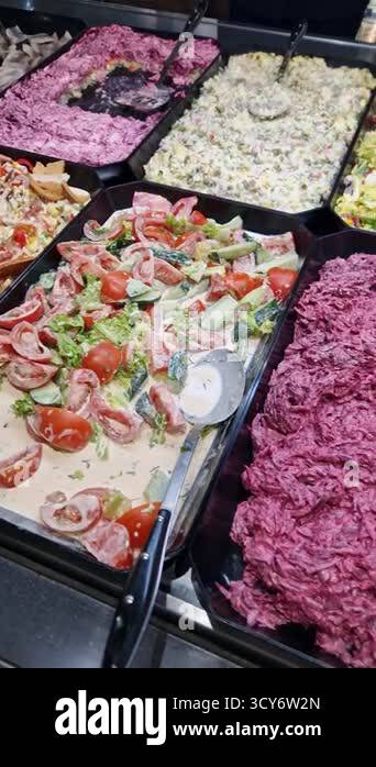 Vertical shot panning across a salad bar buffet, showing a variety of ...