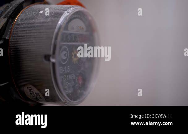 A close-up view of a household water meter with visible dust and ...