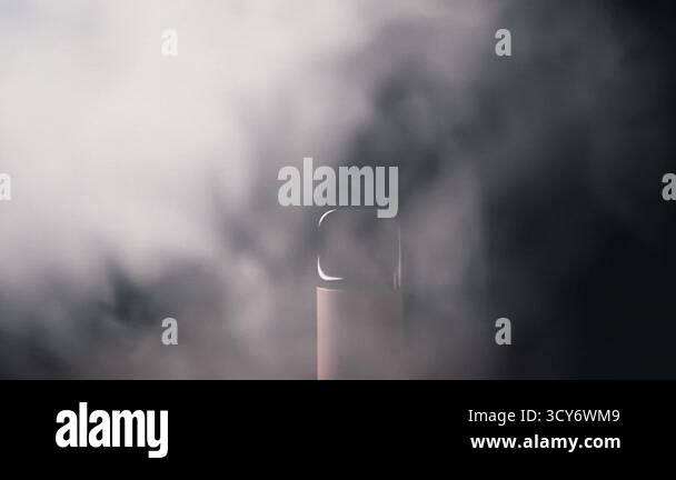 Close-up, Electronic Cigarette or Vape in Smoke on Black Background. A single slender object ...
