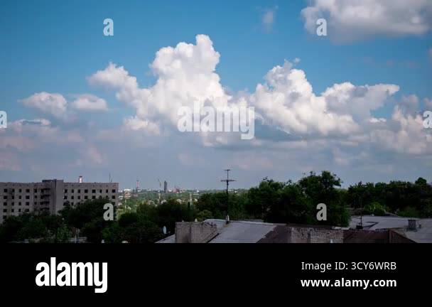 Timelapse view over urban area, showing white cumulus clouds drifting ...