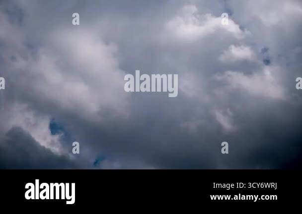 Upward view timelapse of fluffy white cumulus clouds moving quickly ...