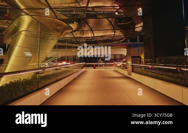 HONG KONG, CHINA - MAY 19 2025: Empty glass corridor and terrace lit by ...
