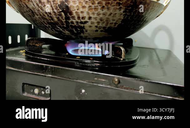 Fiery wok cooking action on a gas stove burner, preparing delicious ...