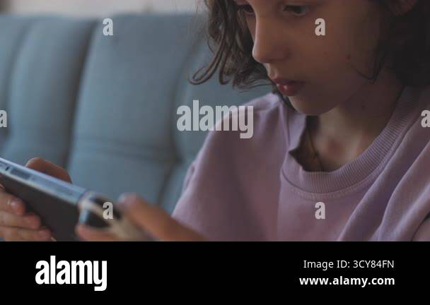 A child plays a computer video game. Hands of a person playing video ...