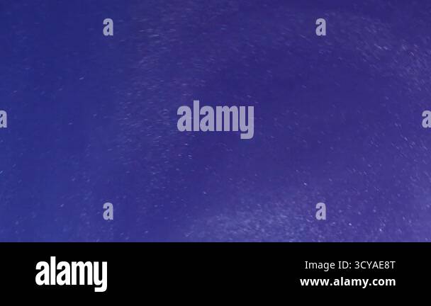 Shimmering art water. Magic stream. Violet paint color liquid defocused ...