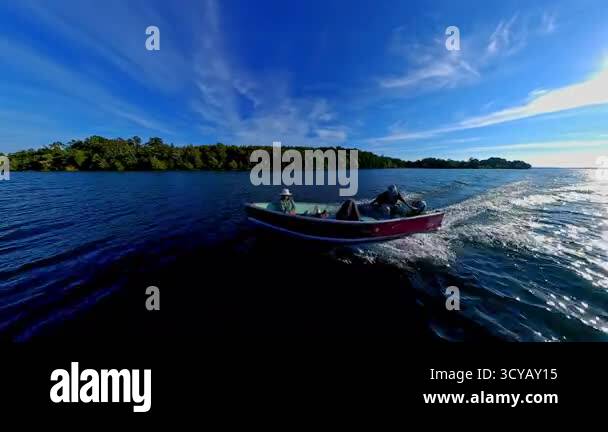 Man driving bass boat while woman seating at the front. Power sport ...