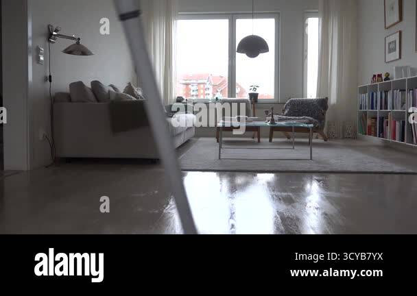 Stockholm, Sweden A man mops the floor with a wet mop inside a modern ...