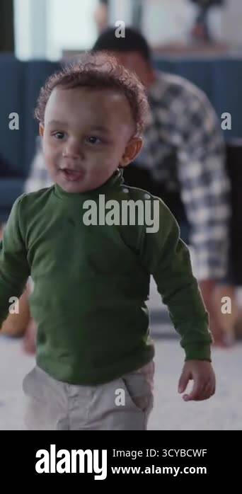 Curious cute african american boy walking inside living room looking ...