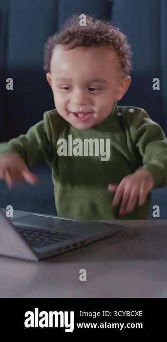 Young cute afro-american little kid playing with laptop tapping on ...