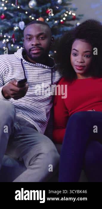 Wife with husband watching TV. Young man turning off TV. Couple ...
