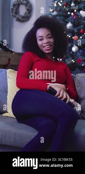Nice African man giving Christmas gift to charming girl with curly hair. Happy girl smiling ...