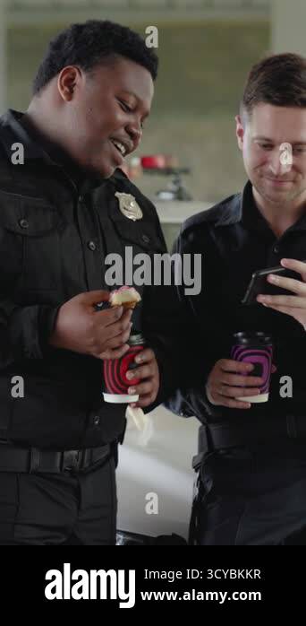 Two police officers enjoy snacks and drinks, sharing camaraderie and ...