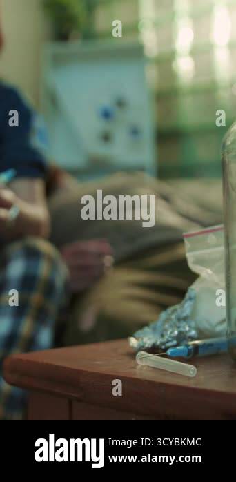 Young woman injects drugs into a vein sit on sofa home syringe ...