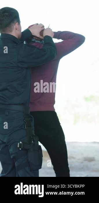 In an urban scene, two men confront each other, one in a red sweater ...