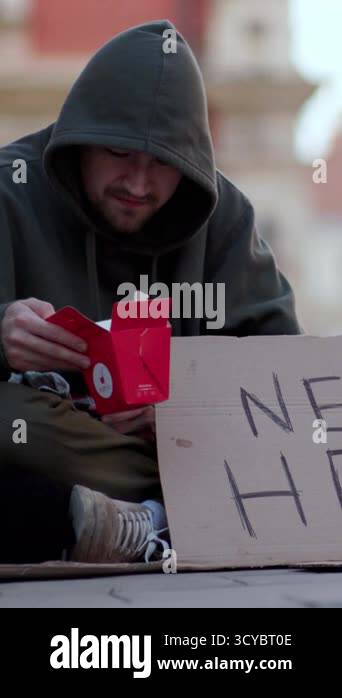 A cardboard sign that reads NEED HELP symbolizes the ongoing struggle ...