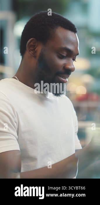 A young man with a neatly groomed beard smiles softly, lost in deep ...