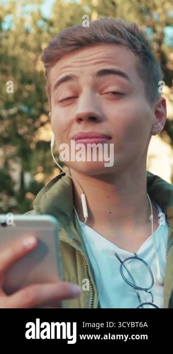 Close up face handsome young man use phone speak on mobile in headphone ...