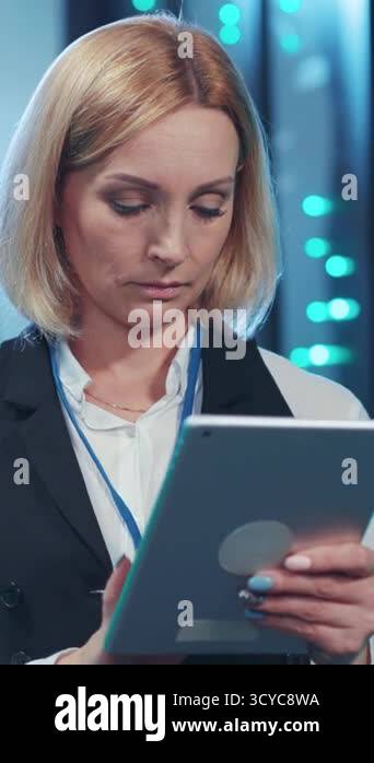 A highly focused professional woman actively engages with a tablet ...