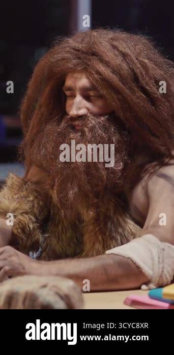 Portrait of Savage Neanderthal Tribesman Sitting in Office Doing Modern ...