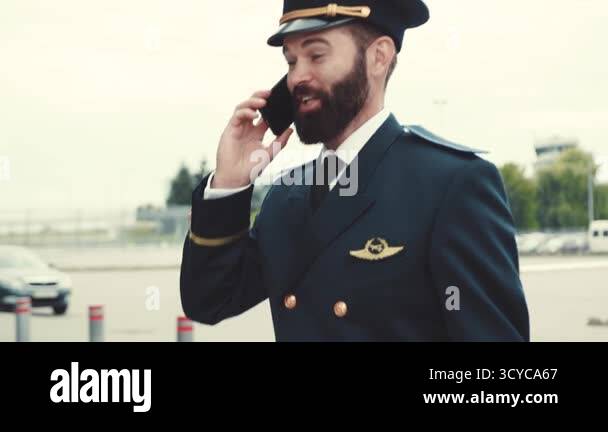 Extremely attractive caucasian bearded pilot in uniform walks by the ...