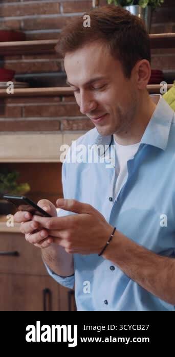 Handsome sociable young man texting message on a smartphone. Portrait ...