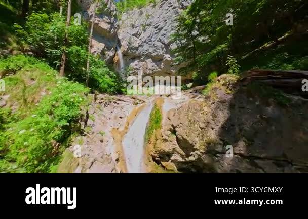 Aerial video of a scenic waterfall cascading down a rocky mountain ...