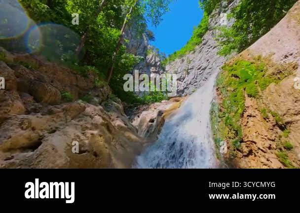 Aerial video of a scenic waterfall cascading down a rocky mountain ...