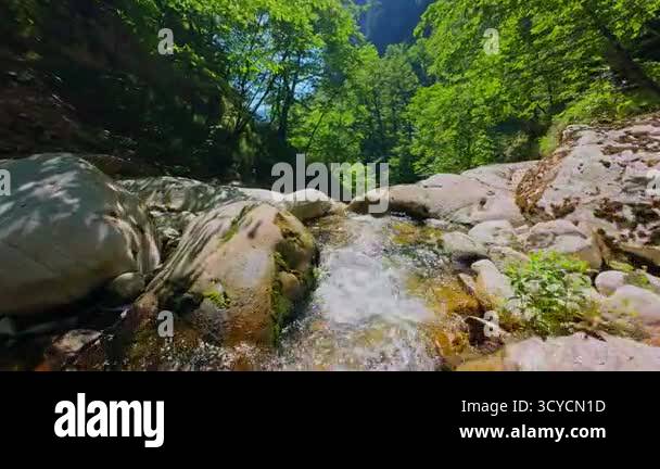 Aerial video of a scenic waterfall cascading down a rocky mountain ...