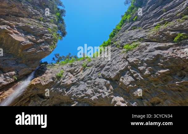 Aerial video of a scenic waterfall cascading down a rocky mountain ...