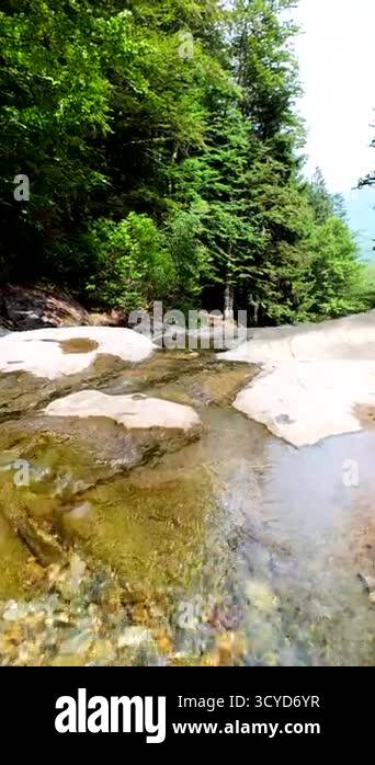 Aerial video of a beautiful waterfall flowing over rocks in green ...