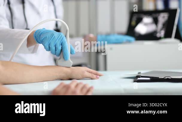 Doctor performs wrist ultrasound examination and guides probe across ...