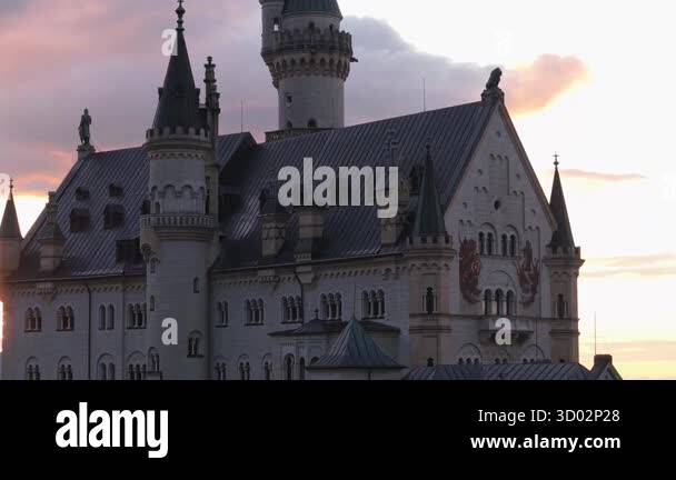 Zoomed-in aerial view of Neuschwanstein Castle at sunset, surrounded by ...