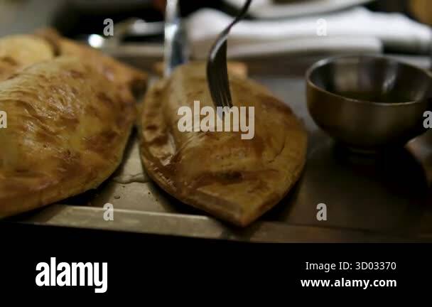 Appetizing baked white fish in golden pastry crust cut open with knife ...