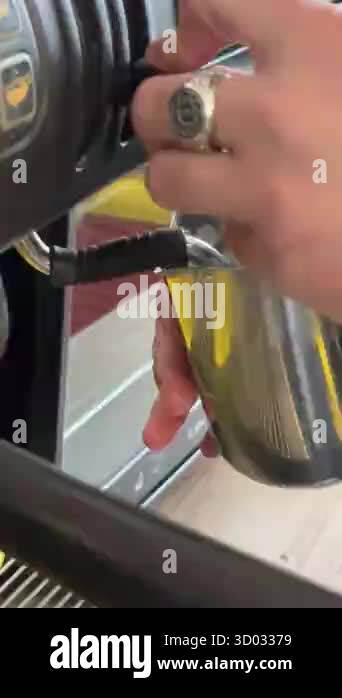 Barista pouring steamed milk into a cup to create latte art, close-up ...