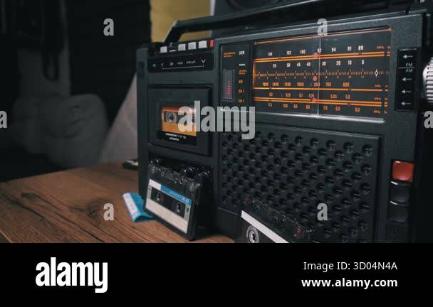 Vintage black boombox with cassette tape playing, sitting on a wooden ...