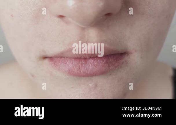 Extreme close-up of a womans face, focusing on the mouth as it slowly ...