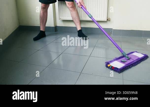 Mopping the floor. Mop washing a wooden floor in an apartment. Man ...