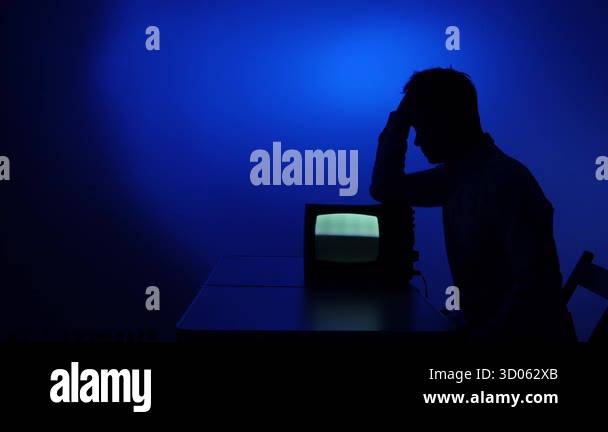 Silhouette of a man resting his head on his hand, feeling anxious and ...
