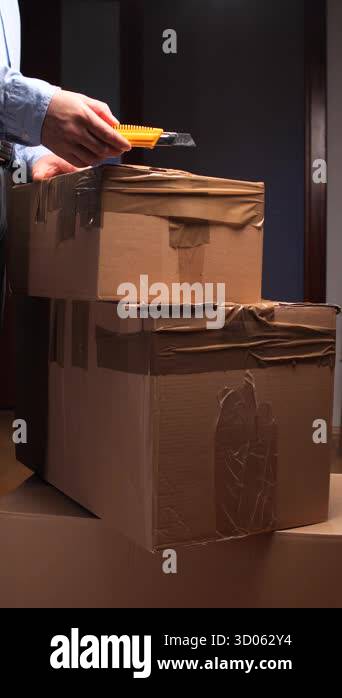 vertical video Person unboxing stacked delivery packages with a yellow ...