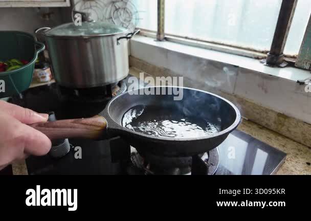 Slow motion A chef in the kitchen frying green and red peppers in a ...