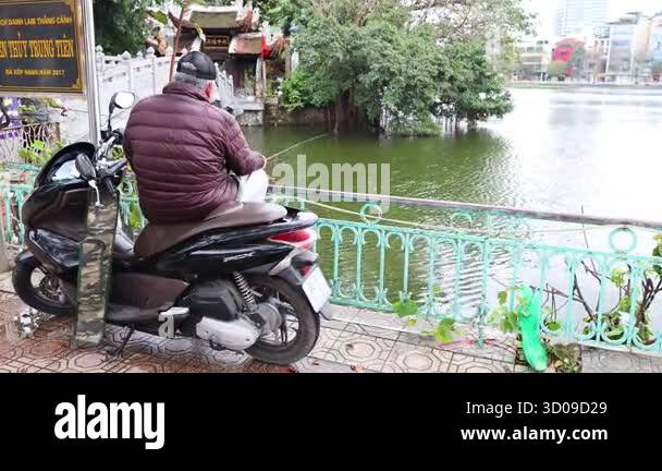 Man fishing from scooter by lake Stock Video Footage - Alamy