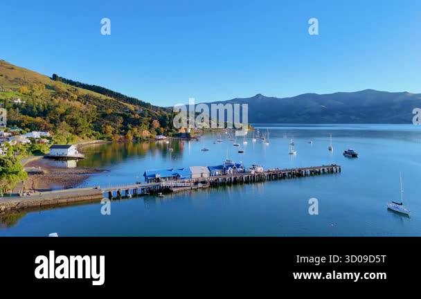 Aerial view of Akaroa Harbour with calm waters, boats, and surrounding ...