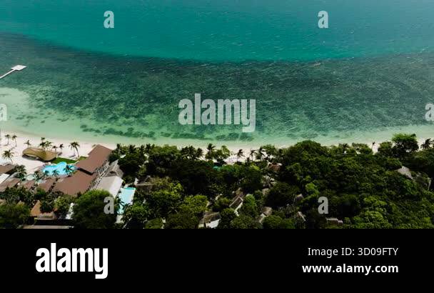 Emerald water and white sandy beach lined with palm trees and a ...