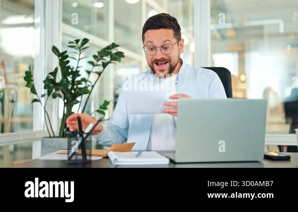 Enthusiastic businessman in a light blue shirt and glasses at a modern ...