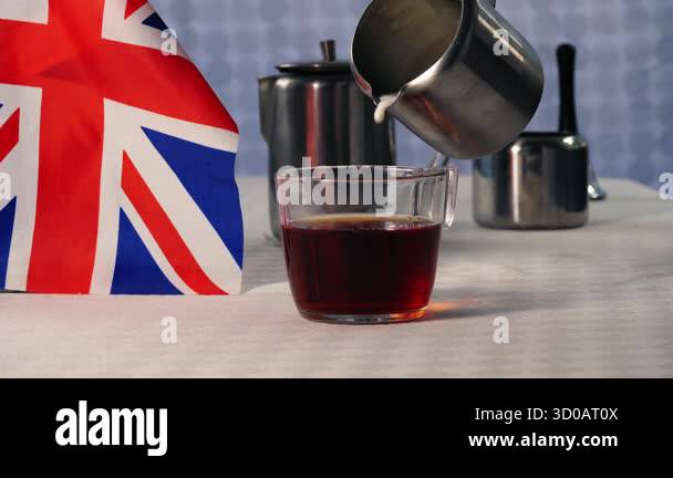Waiter pouring milk into traditional English tea from jug medium 4k ...